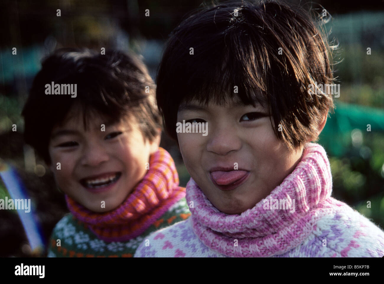 Chinesen zwei Mädchen in eine Zuteilung Grimassen und lachen ...