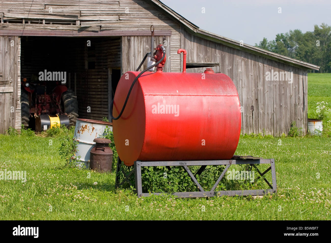 Dieseltank Lagerung Bauernhof mit Scheune und Traktor und Anbaugeräte im Hintergrund ...