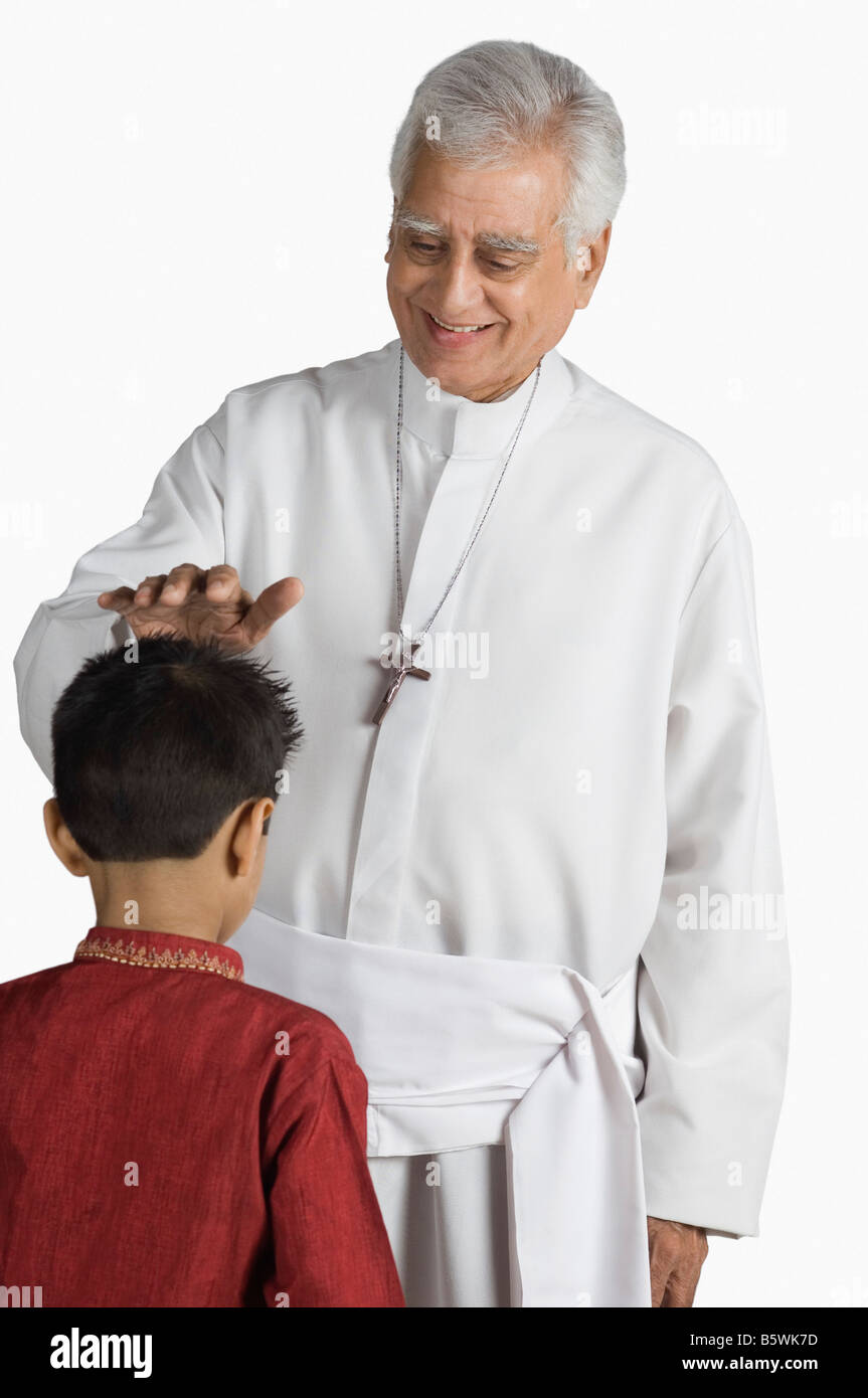 Priester segnet ein Junge, und lächelnd Stockfotografie - Alamy