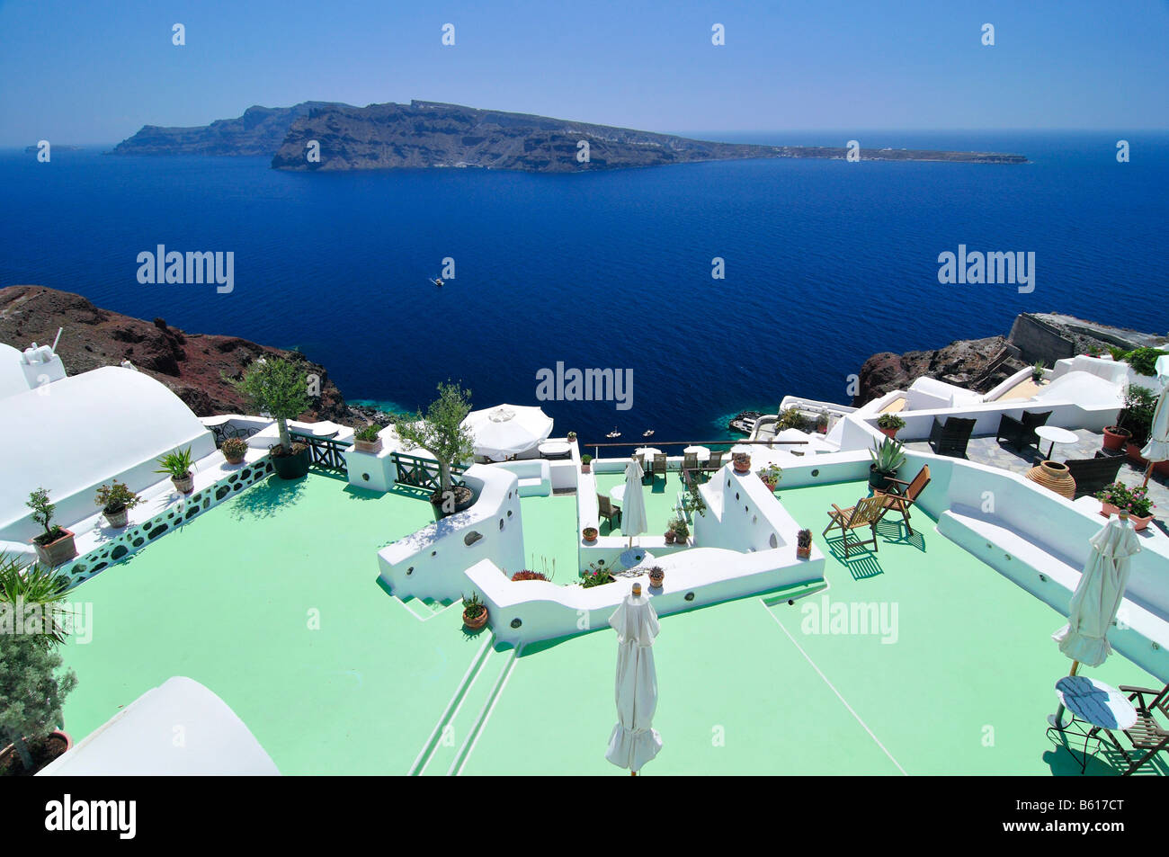 Sonnenterrasse mit einem grünen Boden und Sonnenschirmen vor dem Blau ...