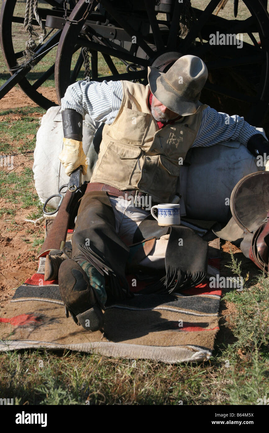 Ein Oldtimer Cowboy lehnte sich gegen seinen Pack und Sattel neben dem ...