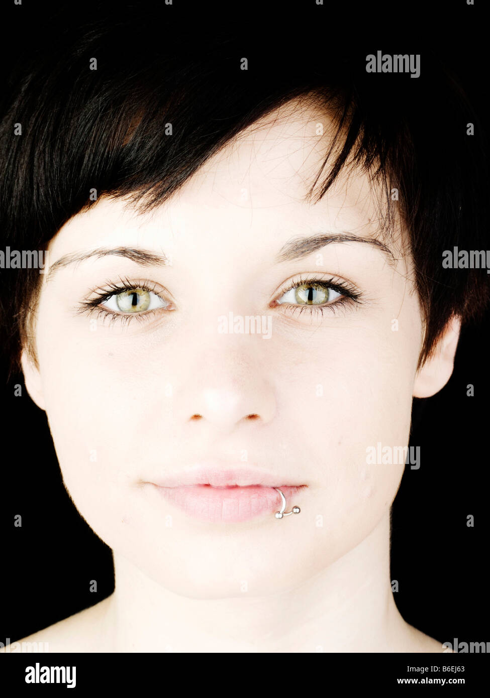 Lächelndes Gesicht eine dunkelhaarige Frau mit einer gepiercte Lippe ...