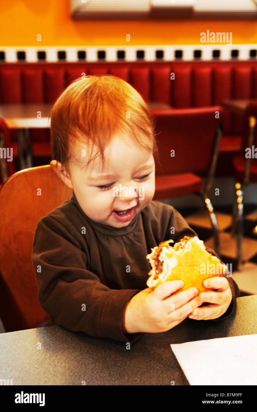 Ein kind isst einen hamburger -Fotos und -Bildmaterial in hoher ...