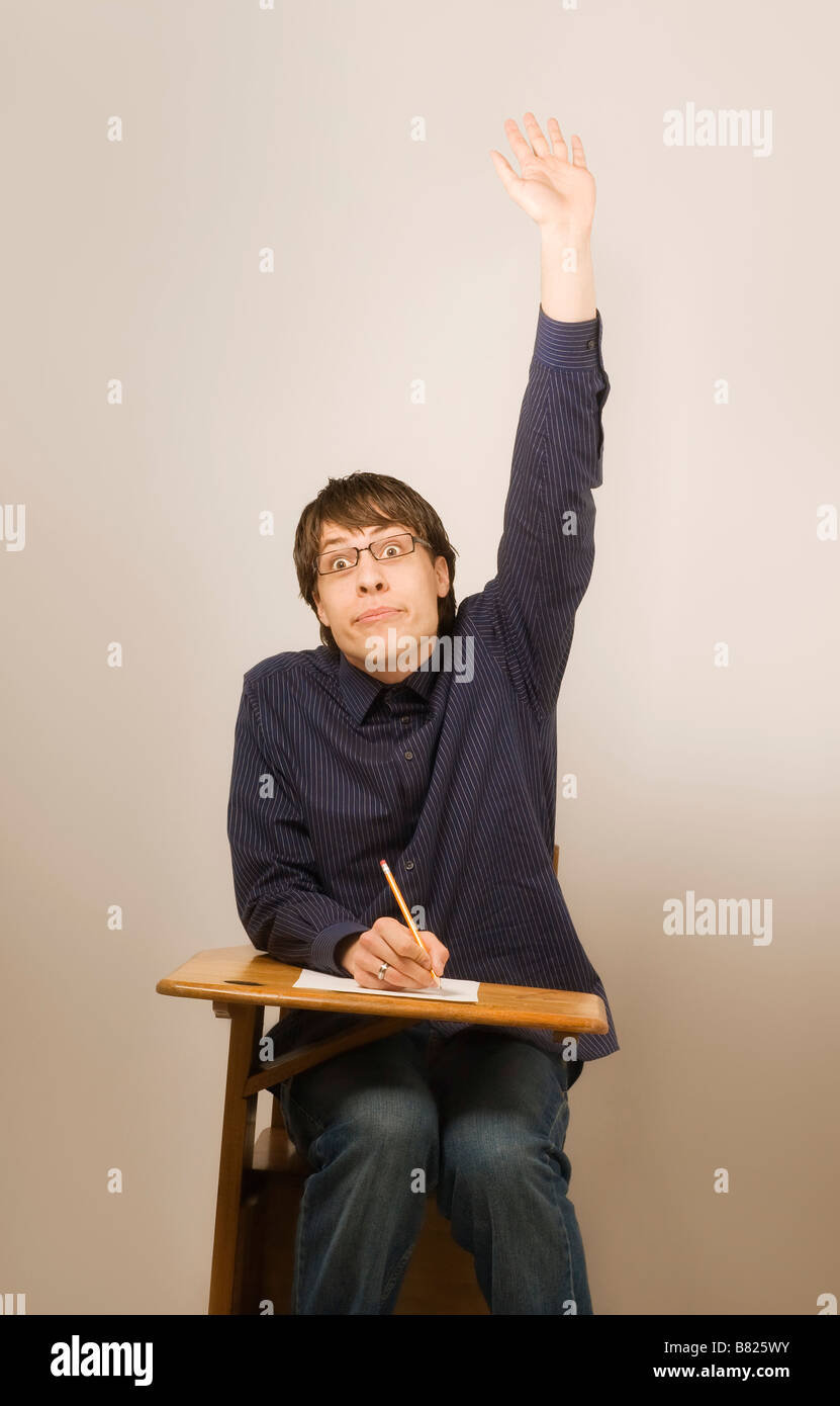 Mann in der Schulbank sitzen Hand heben Stockfotografie - Alamy
