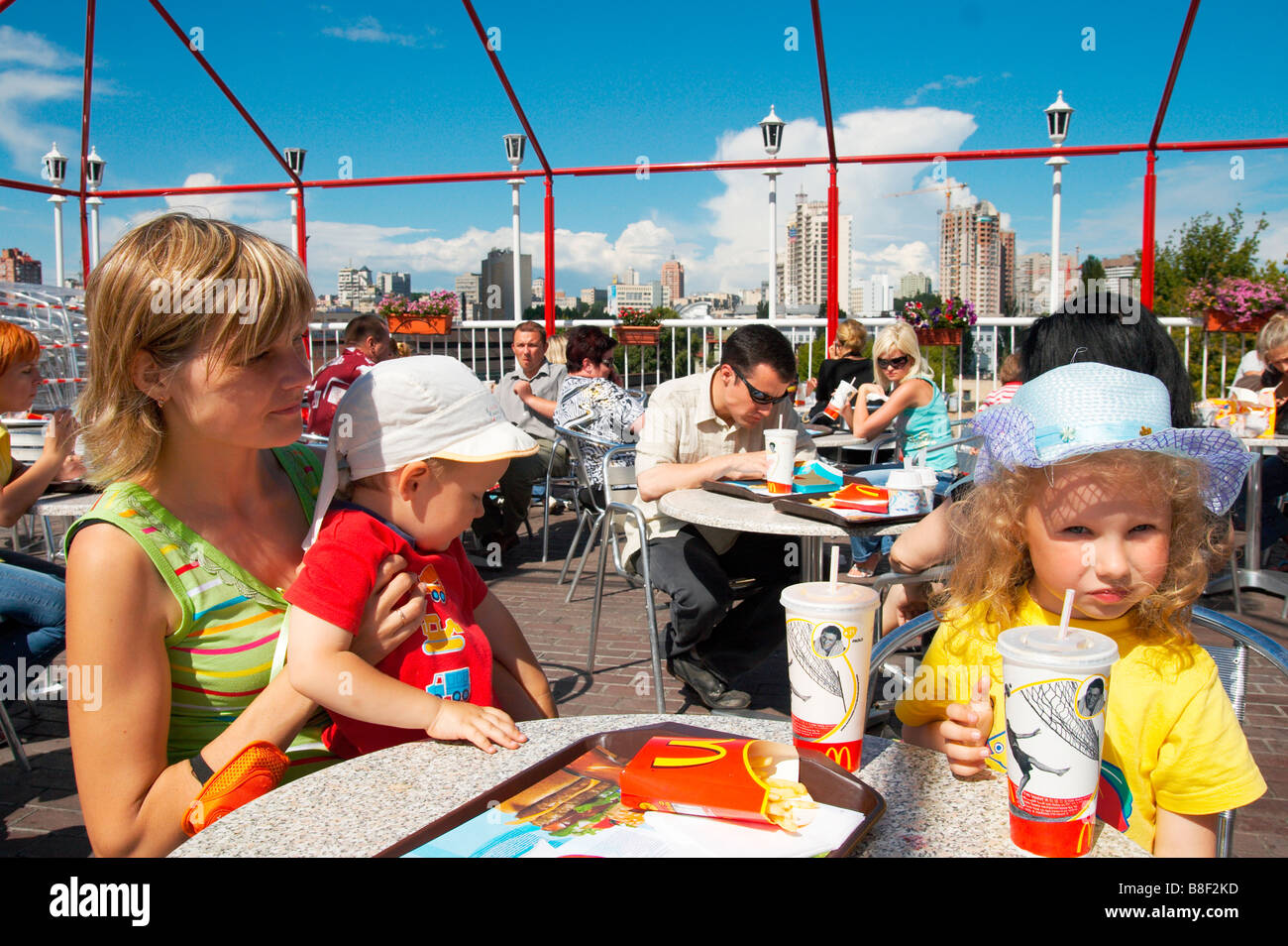 gl-ckliche-familie-mutter-mit-kindern-auf-outdoor-boden-von-mcdonalds