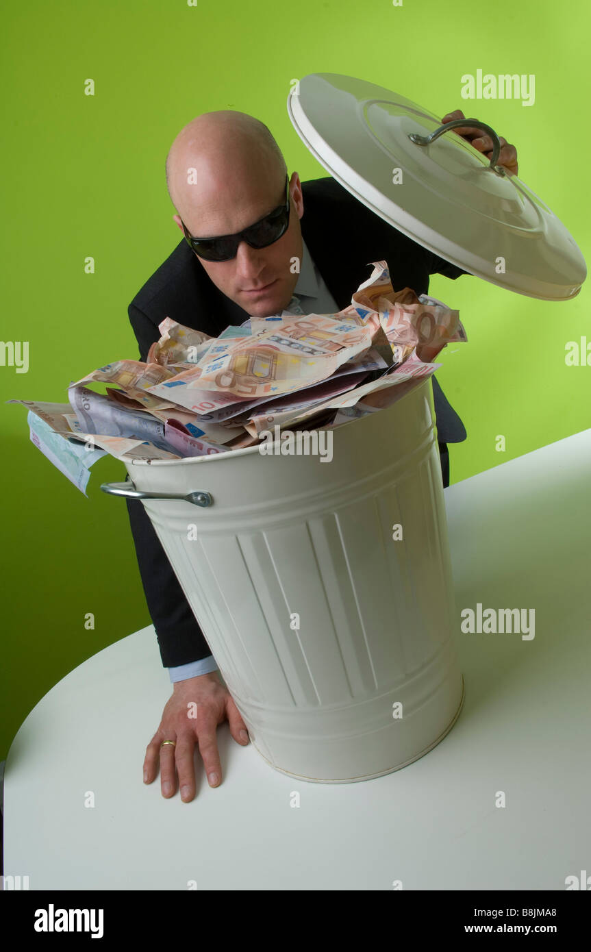 Mann im Anzug mit Mülleimer voller Euro Geld Stockfotografie - Alamy