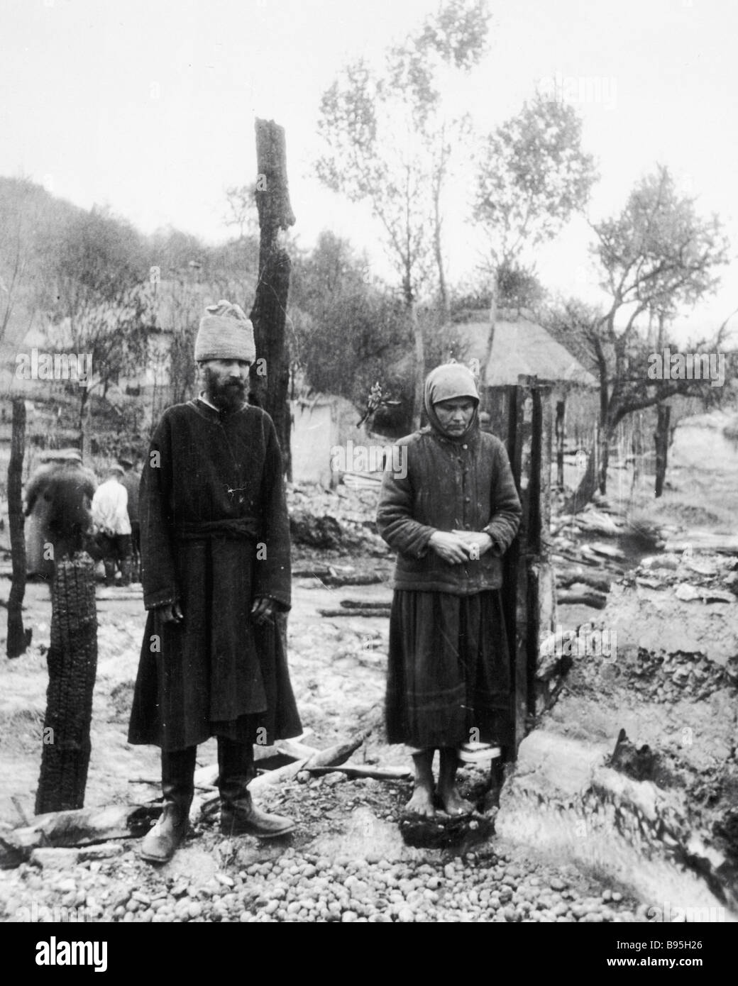 Ein armer Bauer s Familie auf den Trümmern ihres Hauses von Kulaken ...