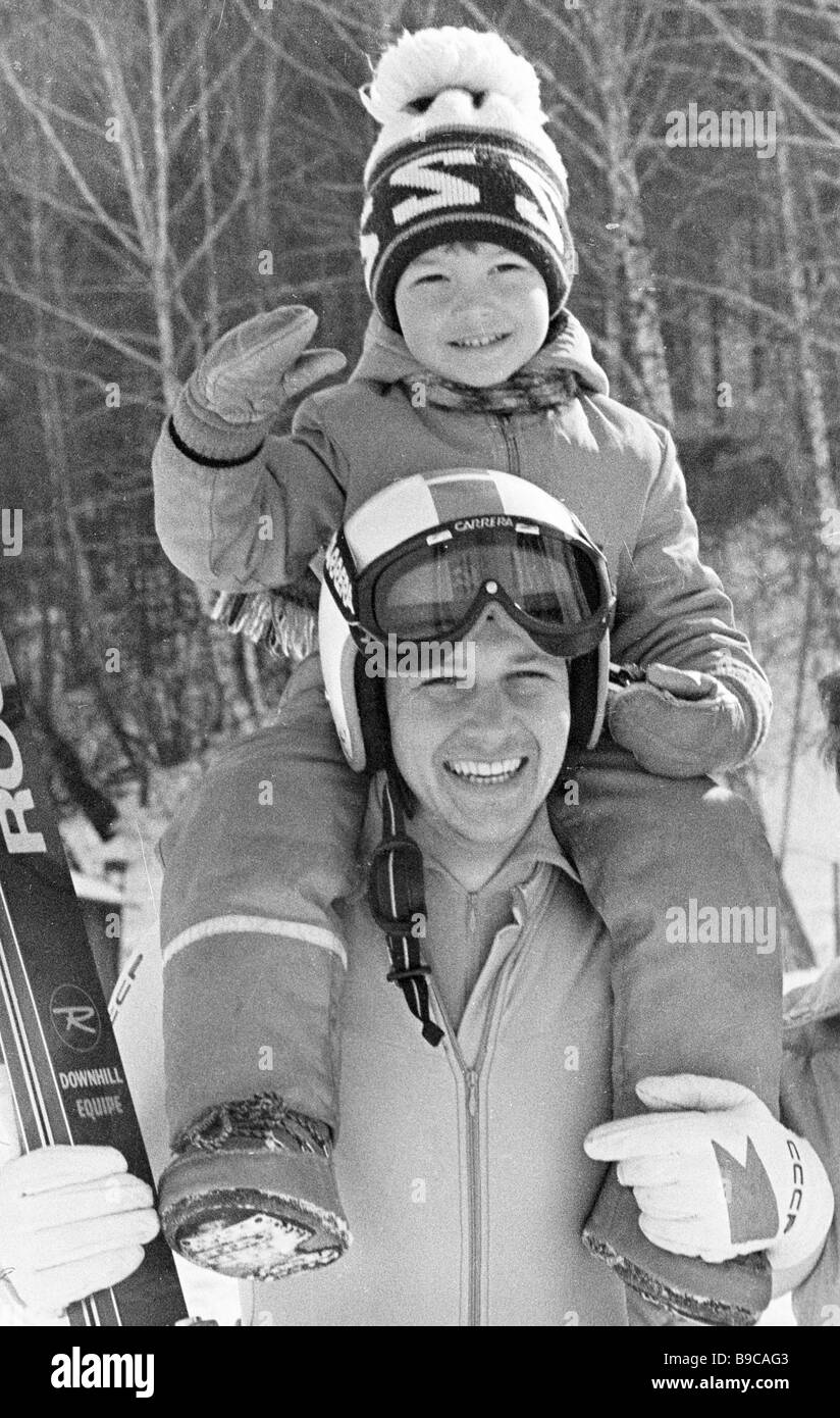 Vladimir Makeev Meister des Sports in den Bergen Skifahren mit seinem Sohn auf den Schultern für ...