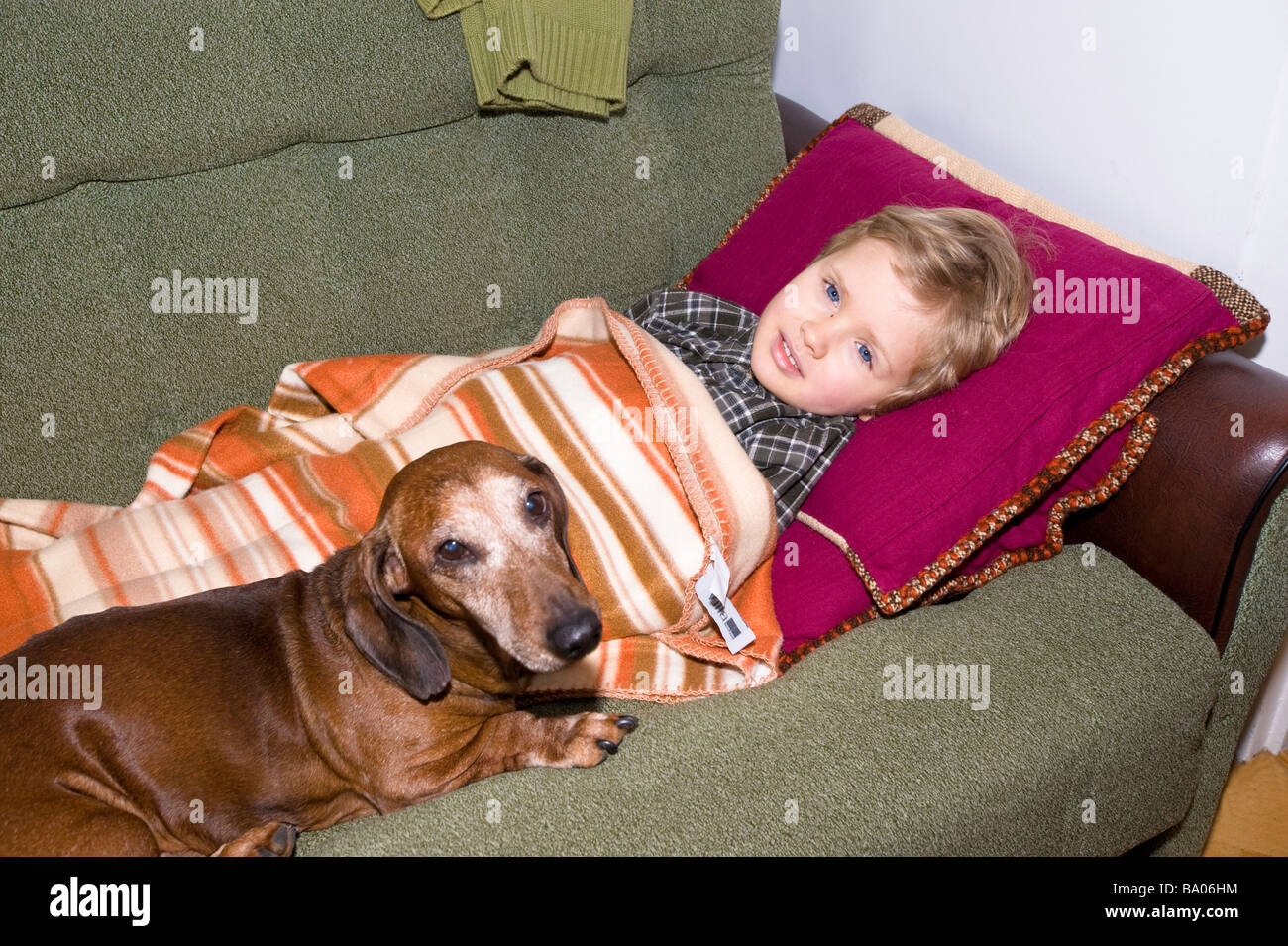 3 Jahre alter Junge Gefühl nicht gut ausruhen mit einem Hund auf Sofa ...