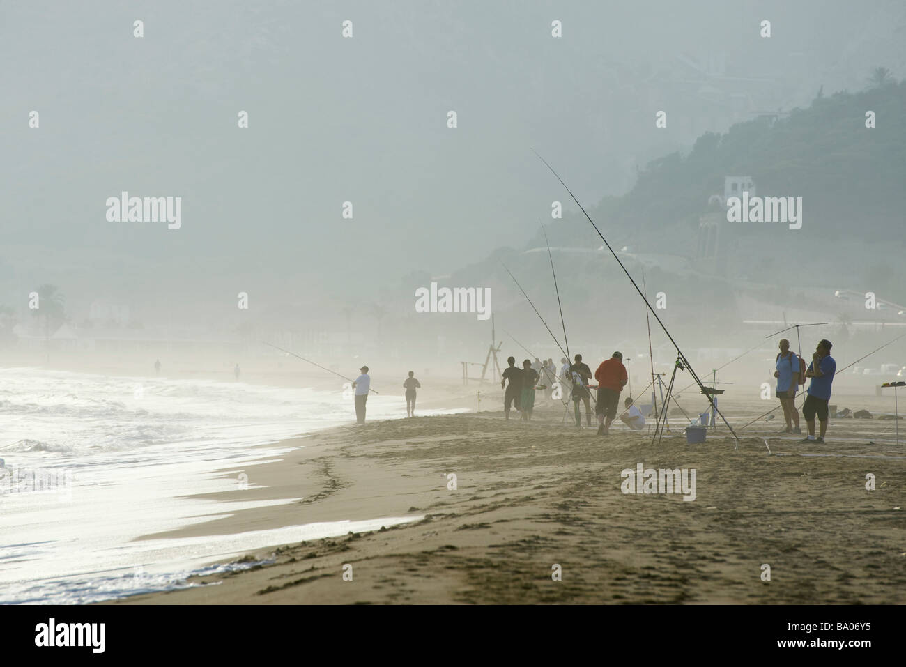 Gruppe von Menschen, die an nebligen Strand Angeln Stockfotografie - Alamy