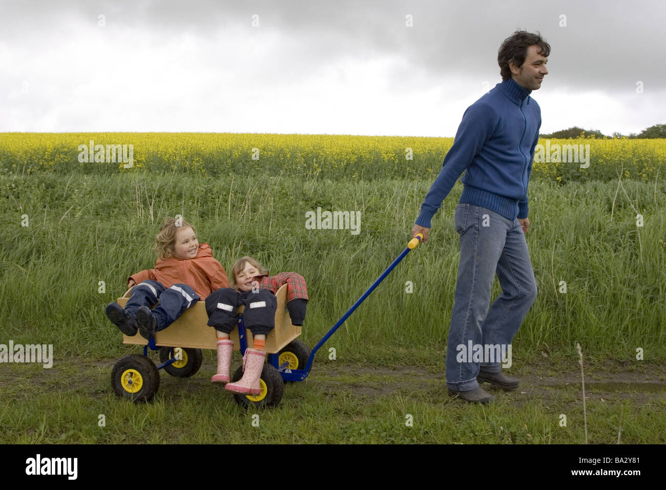Track-Vater-Mädchen, die Bollerwagen fröhlich zieht Frühling Serie ...