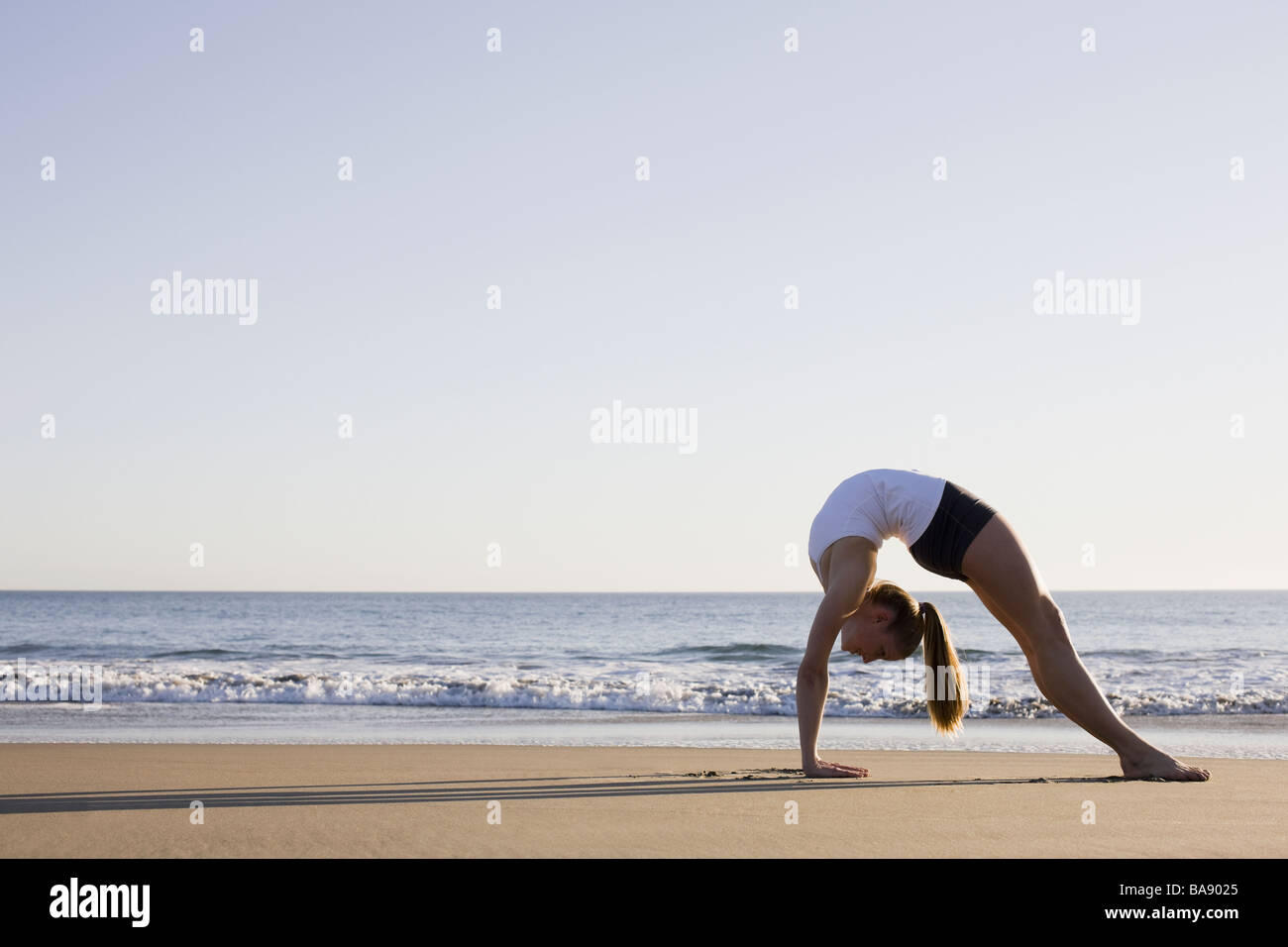 Frau beim Yoga am Strand Stockfotografie - Alamy