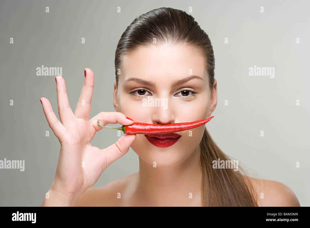Young woman biting chilli -Fotos und -Bildmaterial in hoher Auflösung ...