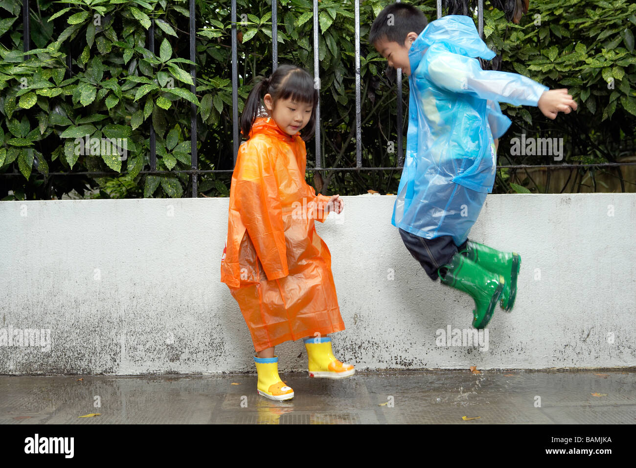 Junge Kinder im Regen mit Regenmäntel Stockfotografie - Alamy