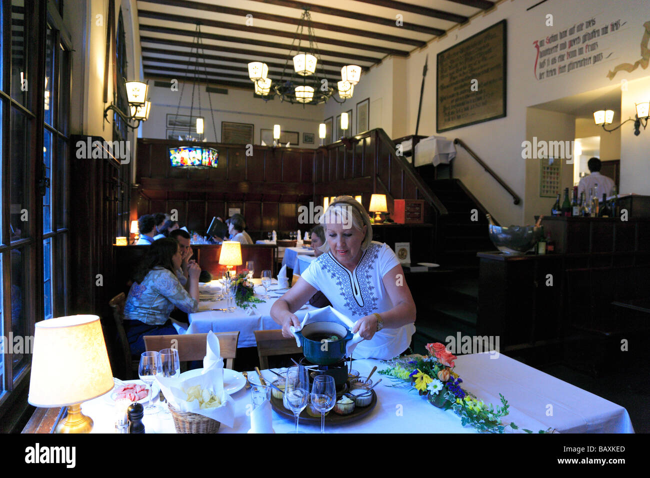 Kellnerin serviert einen Fondue im Restaurant Safranzunft, Fondue ...