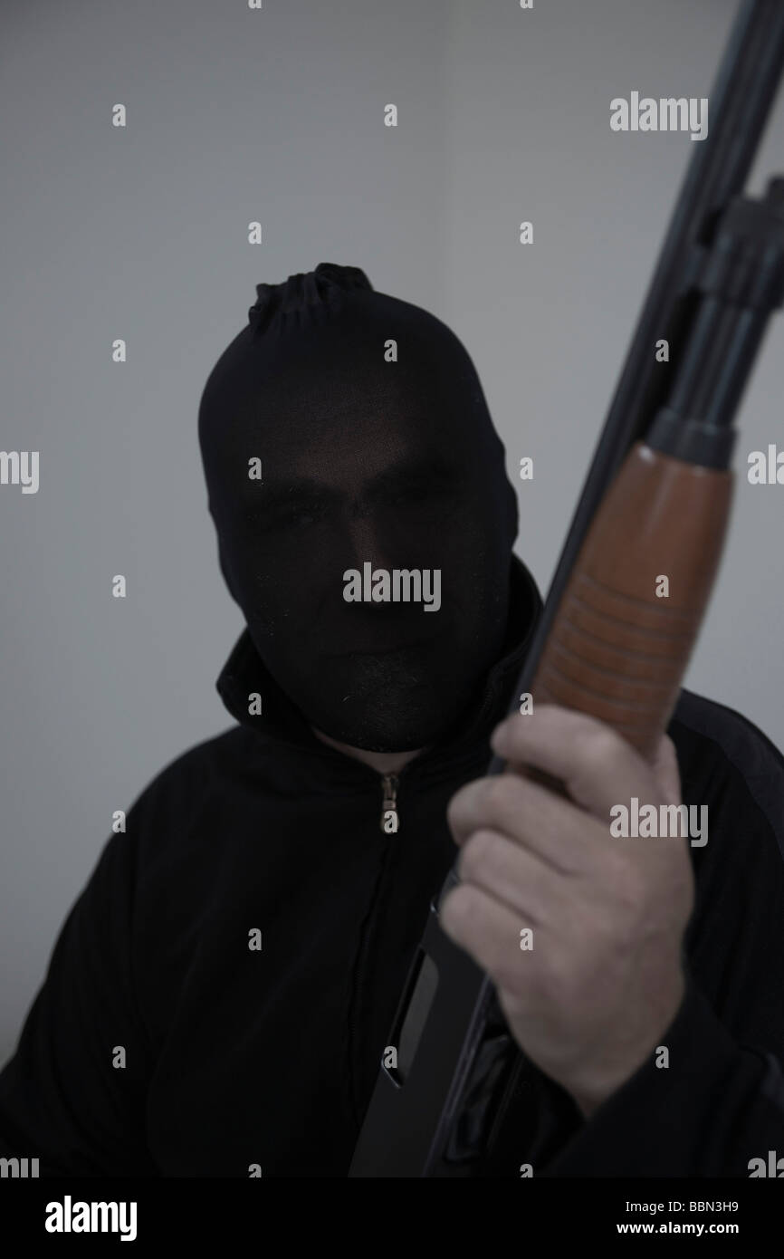 Ein maskierter Mann mit einer Pistole in der hand Stockfotografie - Alamy