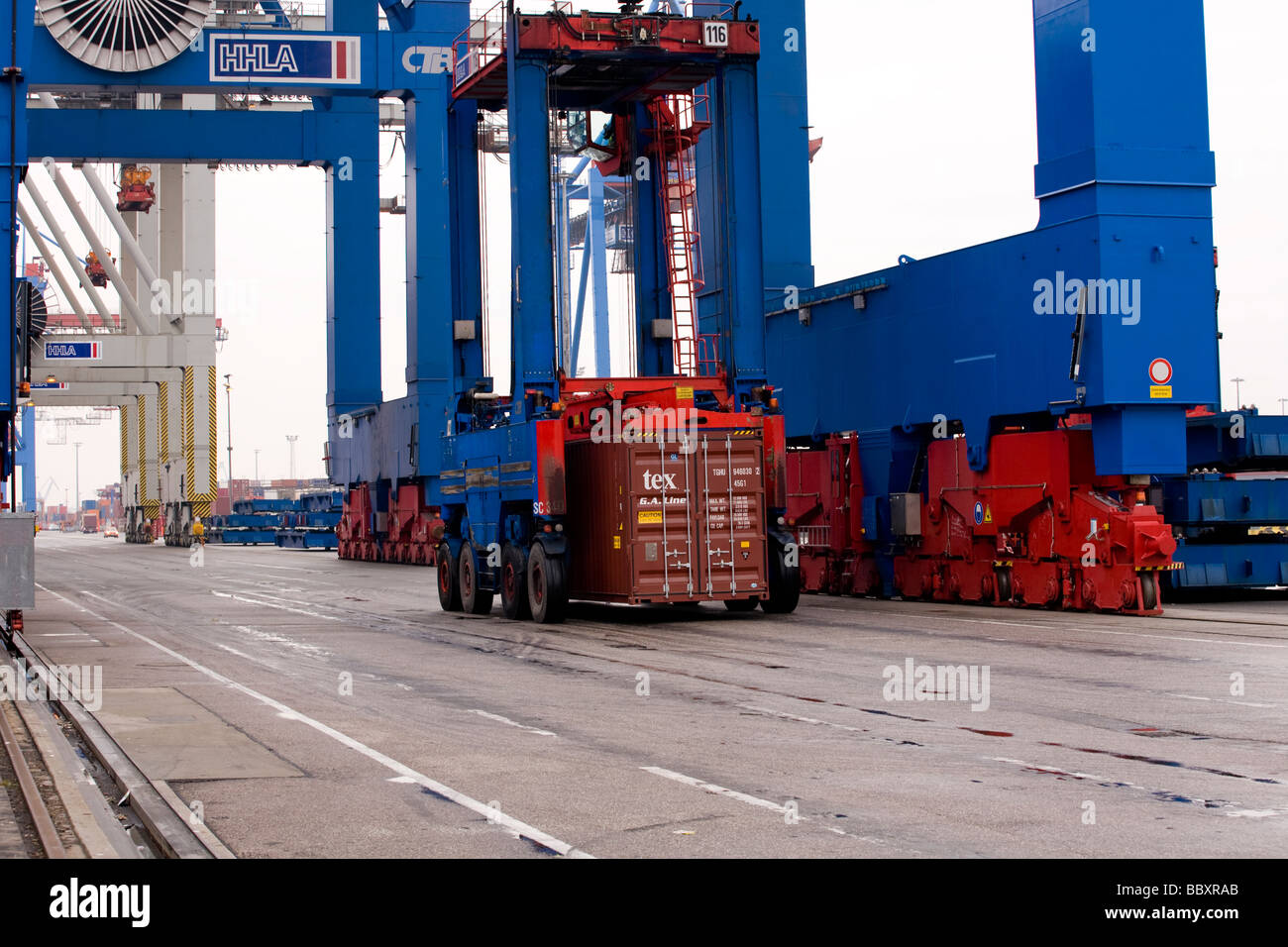 Ein Straddle Carrier LKW zieht ISO-Container vom Hafen Terminals weiter ...