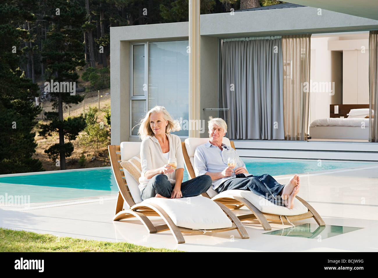 Applying paar entspannend auf den Liegestühlen am Pool Stockfotografie ...