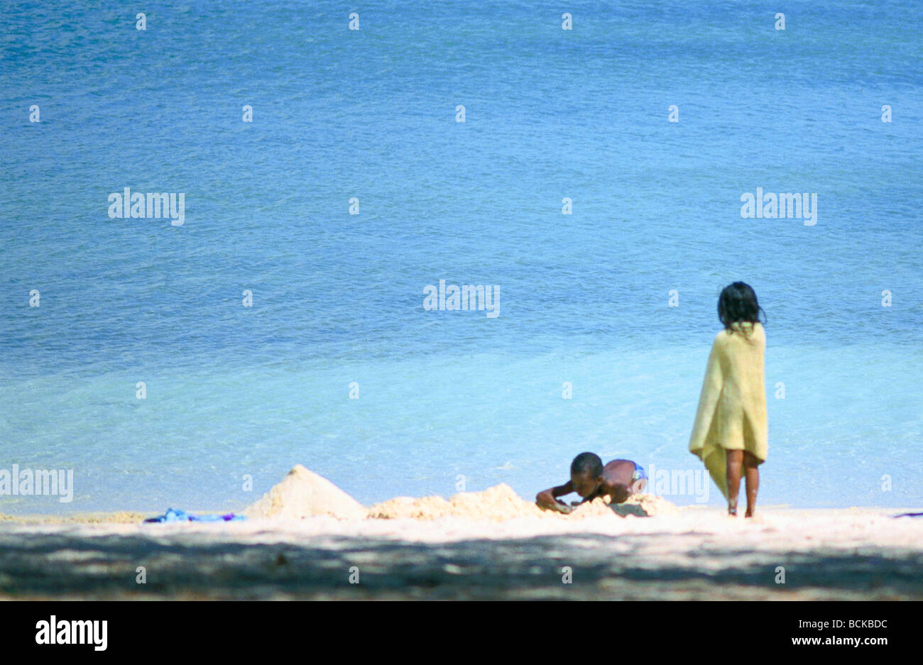 Kinder spielen im Sand am Strand, blaues Meer im Hintergrund ...