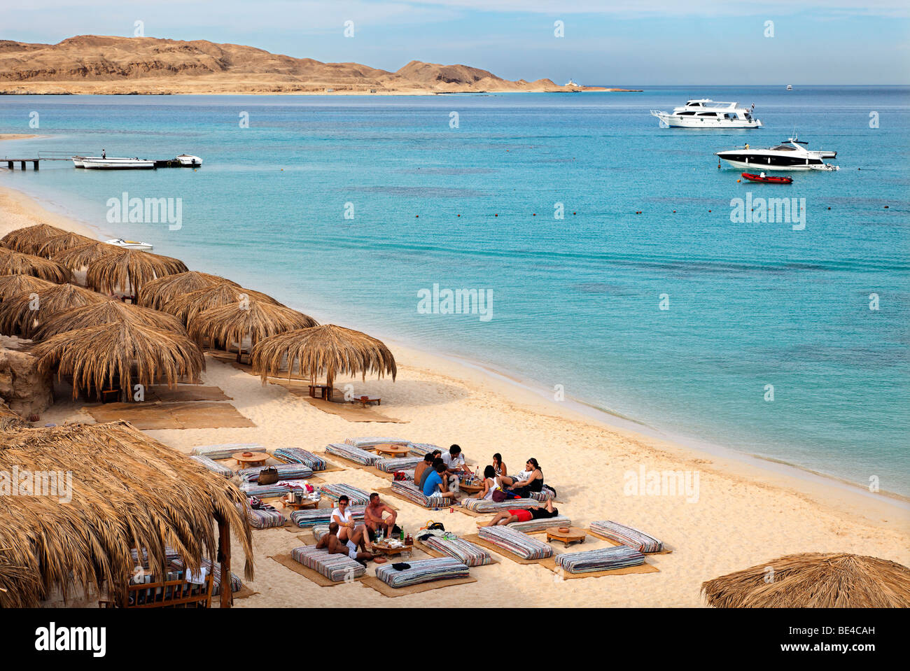 Menschen am Strand auf Kissen sitzen, Strand, Sonnenschirme, Lagune ...