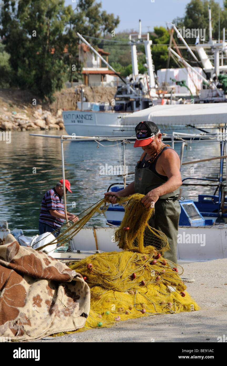 Fischer sortieren Netze am Kai im kleinen Fischerdorf Dorf von Nea ...