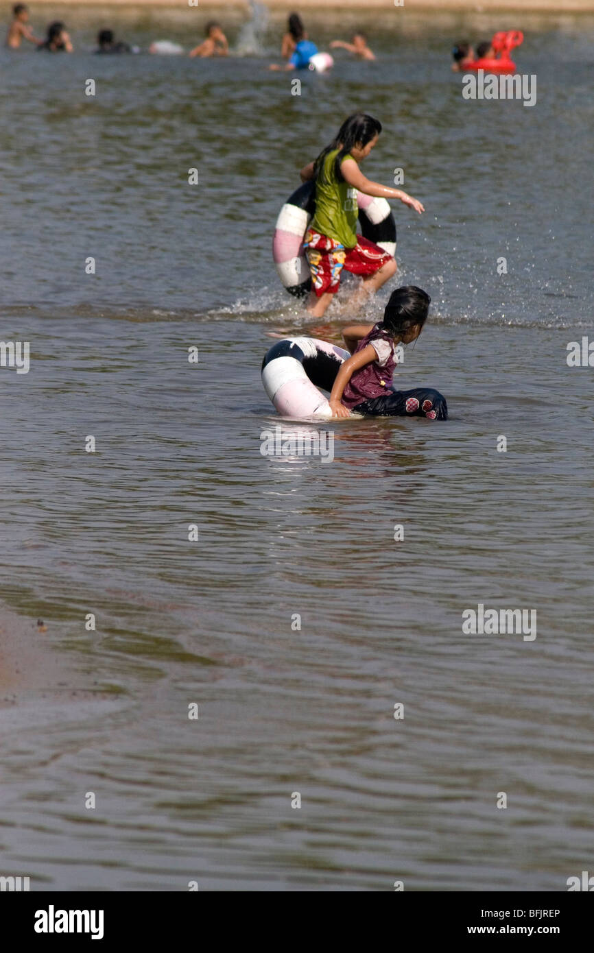 Kinder spielen im Wasser auf ihre Schläuche in Huay Tang Tao Lake in ...