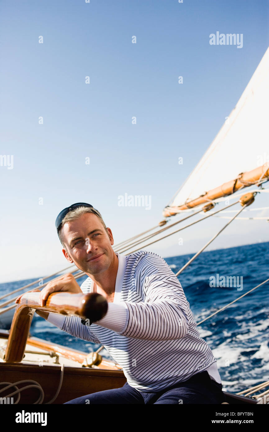 Mann, die Lenkung ein Segelboot Stockfotografie - Alamy