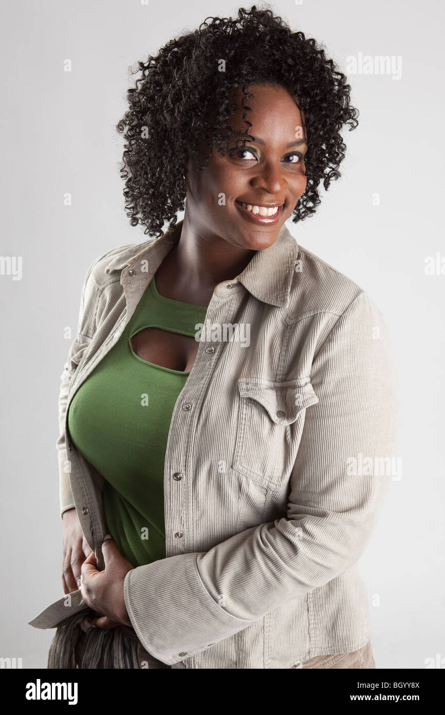 Glücklich und hübsche schwarze Frau trägt ein nettes Outfit im studio ...