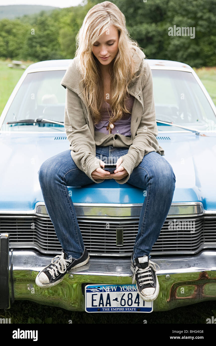 Young woman sitting on car bonnet -Fotos und -Bildmaterial in hoher ...