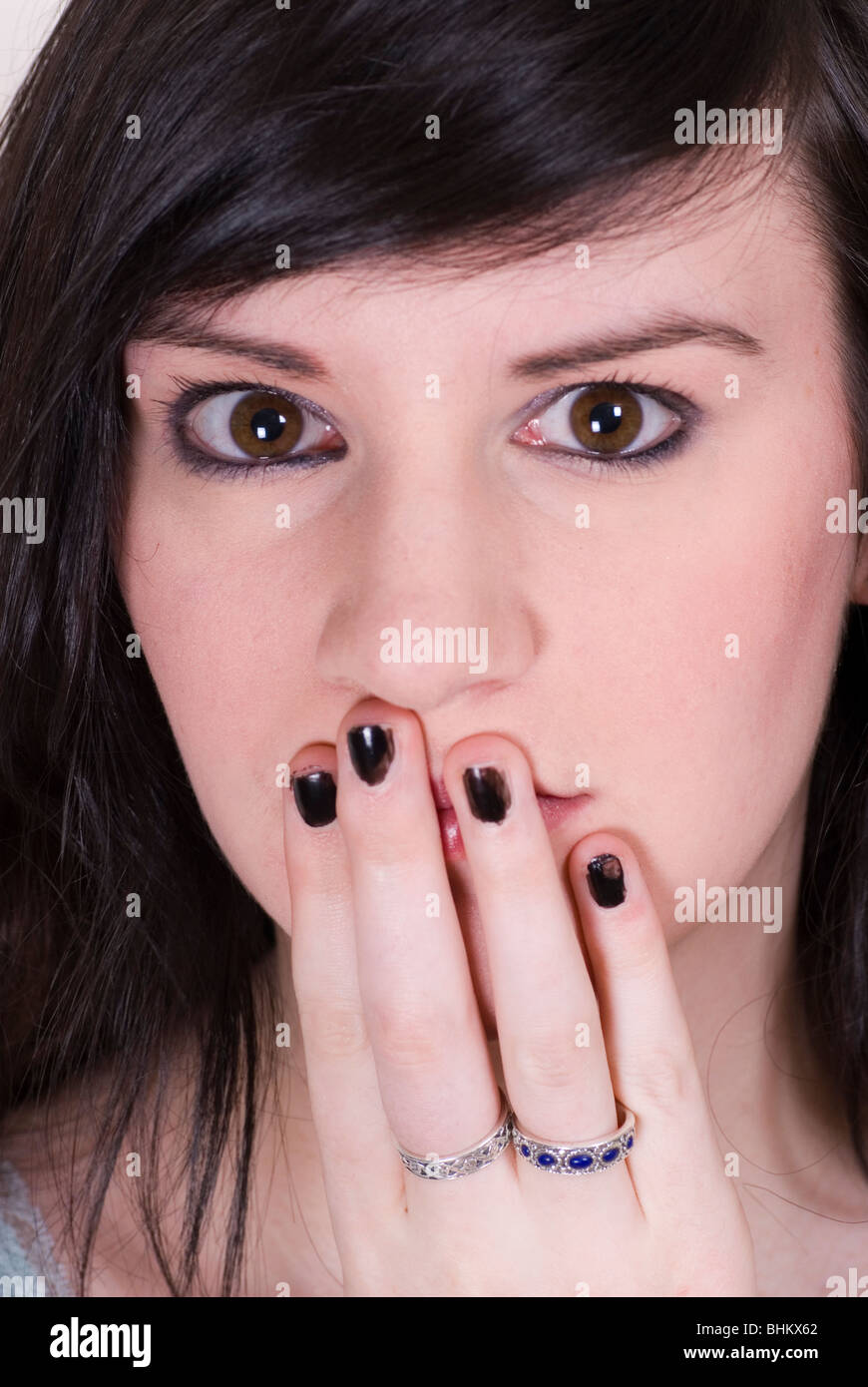Schöne junge Frau Hand den Mund zu Stockfotografie - Alamy