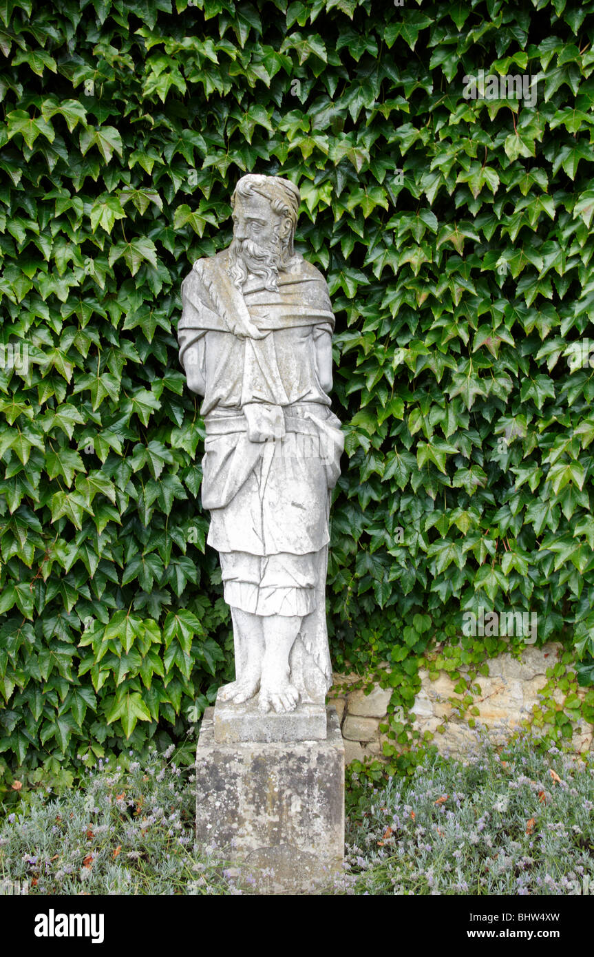 Eine klassische Statue mit einer Efeu-Hecke im Hintergrund ...