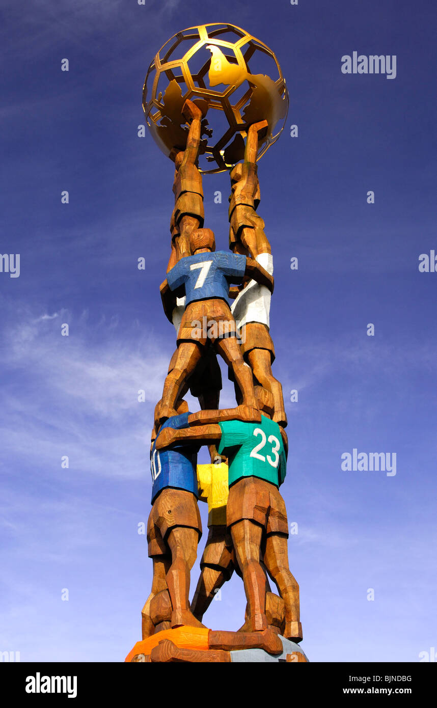 Fußball-Denkmal als Pyramide von Fußballspielern hält einen Globus an ...