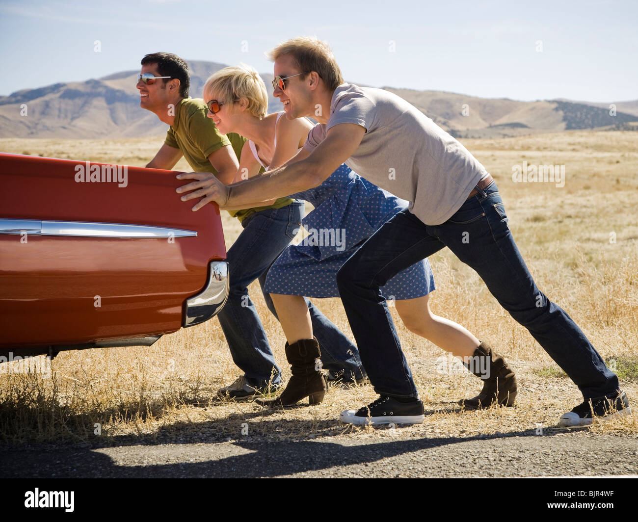 Three people pushing car -Fotos und -Bildmaterial in hoher Auflösung ...