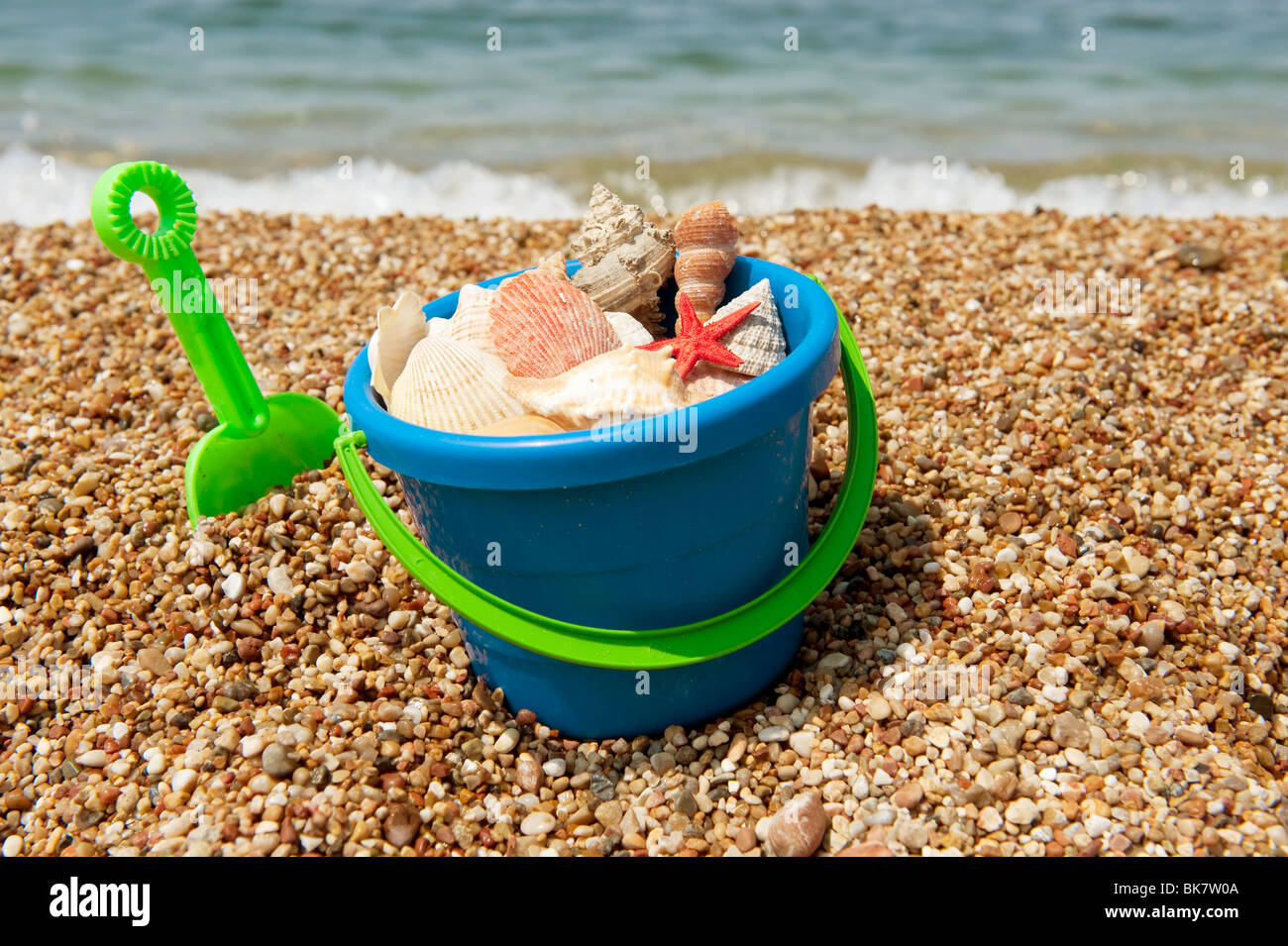 Eimer mit Muscheln im Sand am Strand Stockfotografie - Alamy