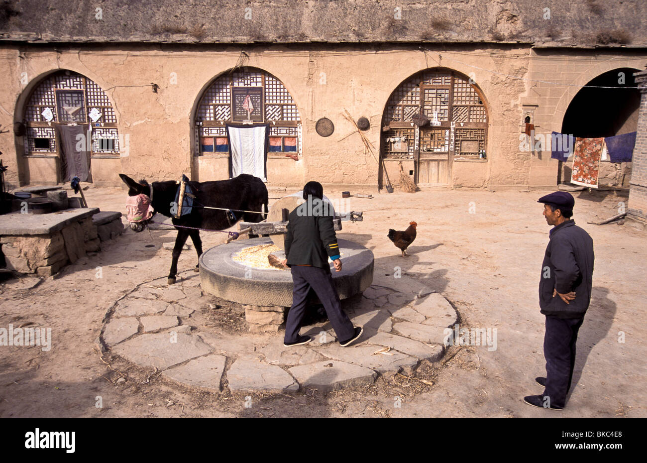 Chang-Lin und Du Mei Mühle Mais im Hof mit ihrer Höhle Haus im ...