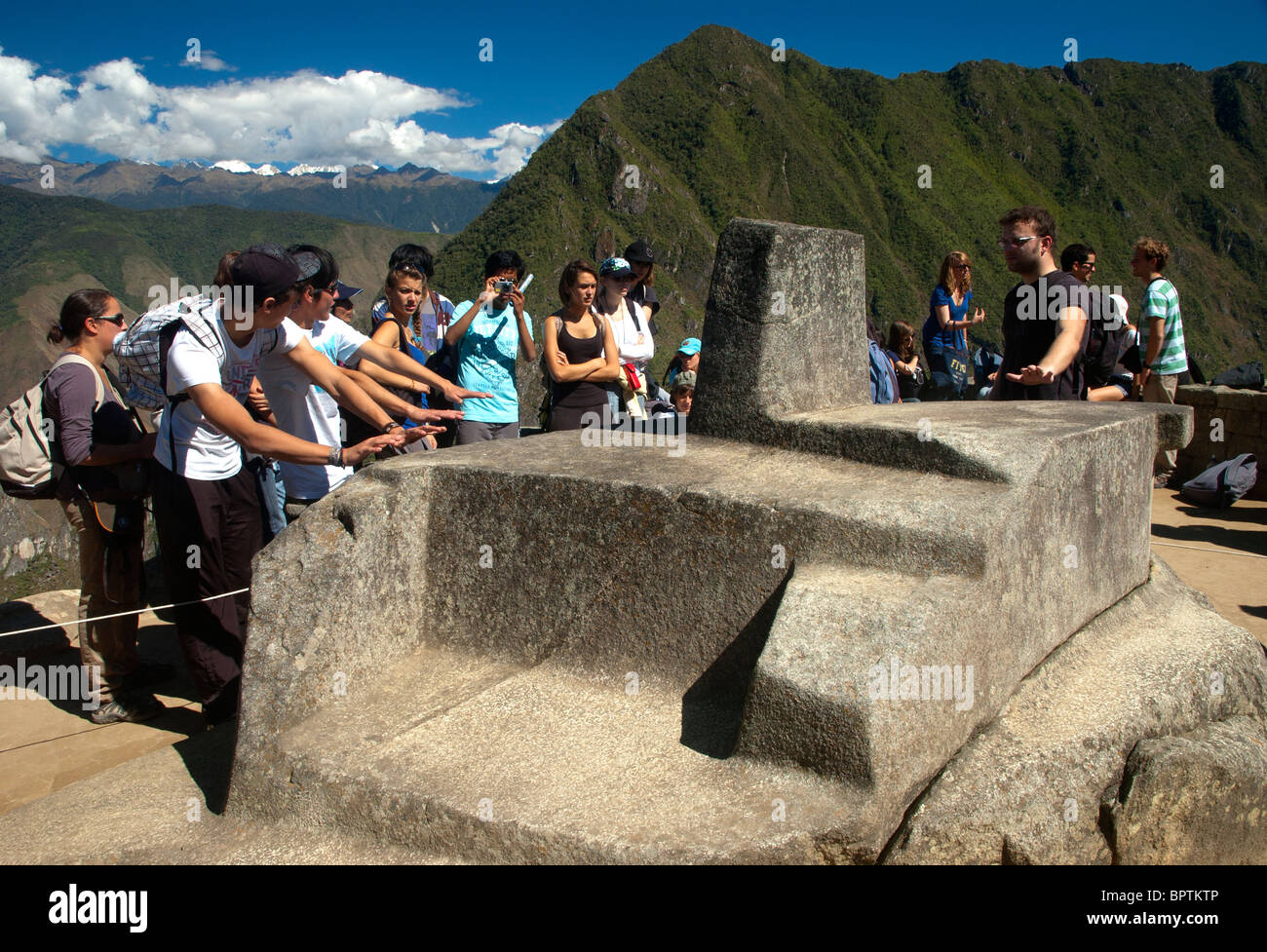 Touristen umgeben die Intihuatana, oder "Hitching Post der Sonne', an der alten Inka-Stadt Machu ...