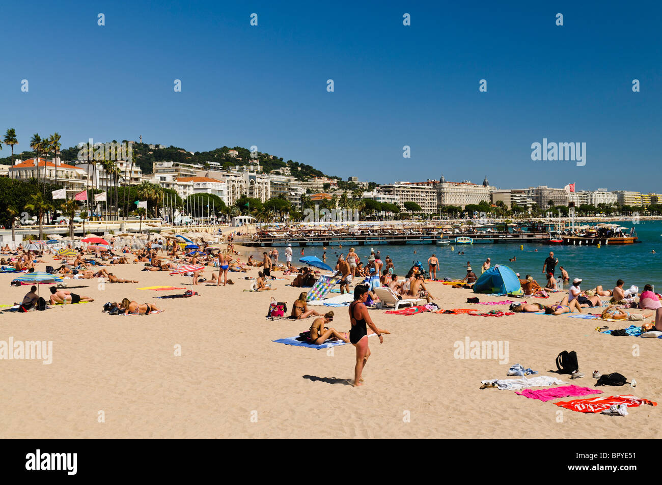 Menschen, die zum Sonnenbaden am Strand von Cannes, Frankreich ...