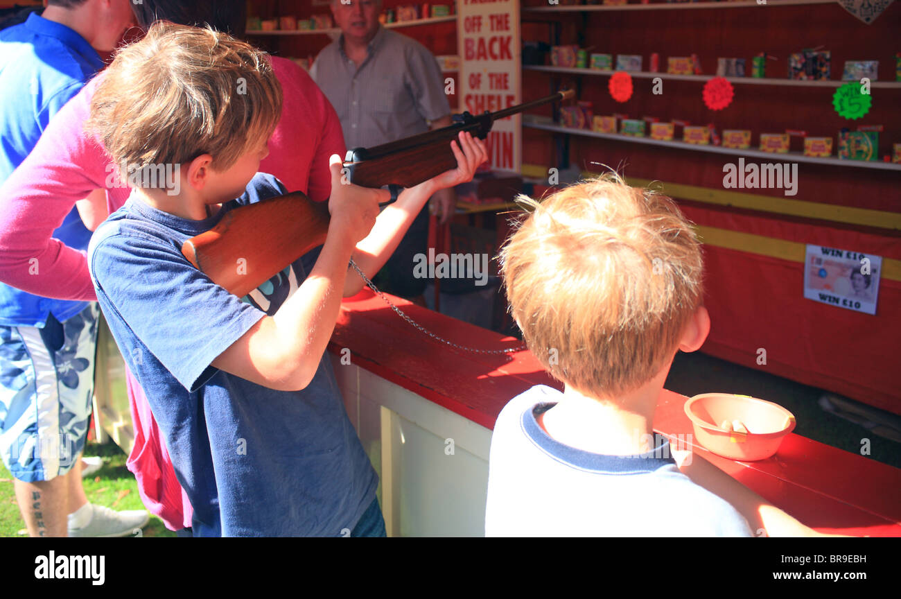 Junge schießen mit einem Luftgewehr in ein Arcade-Spiel auf Challock ...