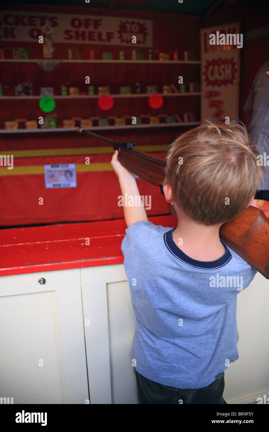 Junge schießen mit einem Luftgewehr in ein Arcade-Spiel auf Challock ...