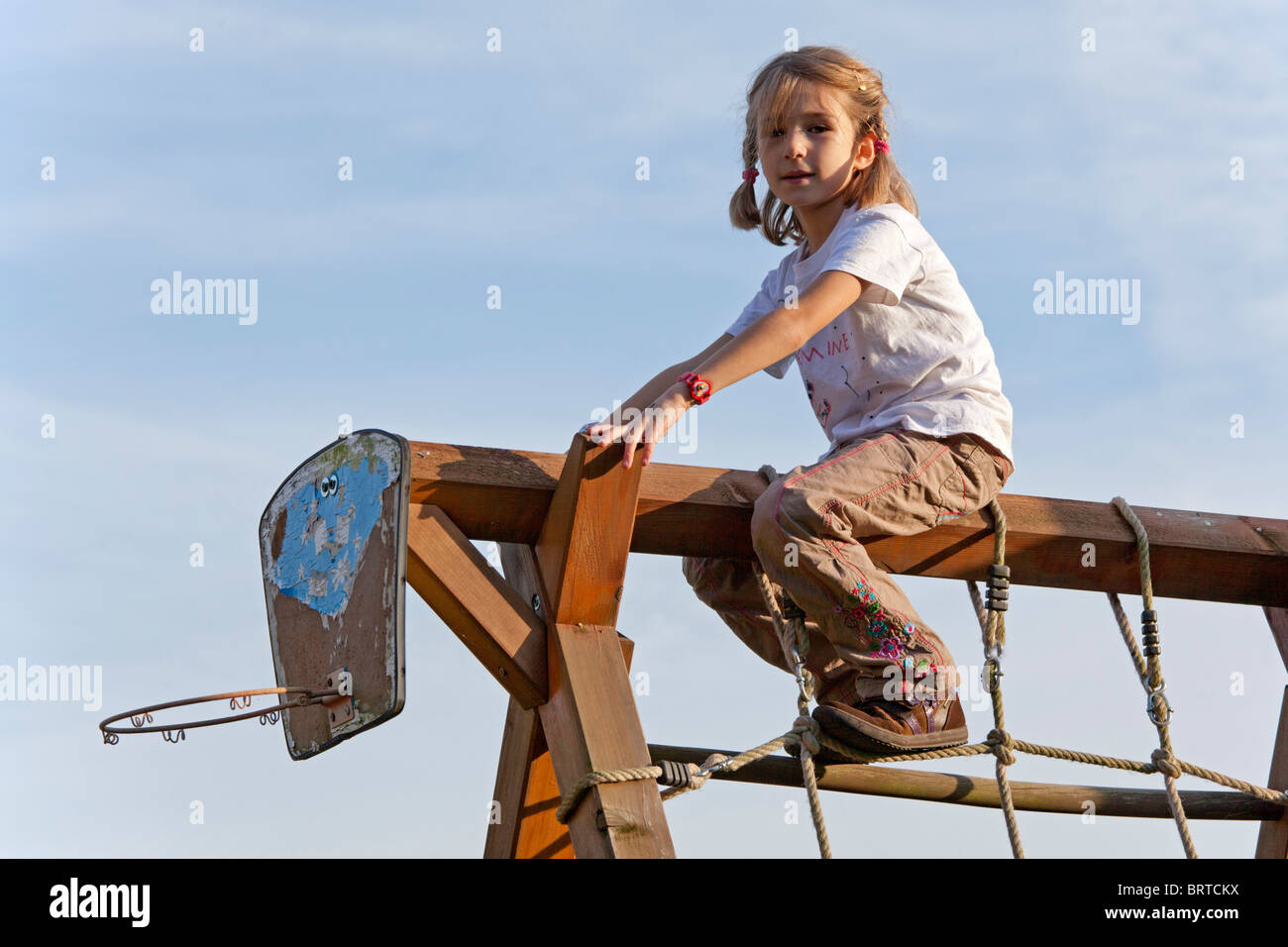Kleines Mädchen Sitzt Auf Klettergerüst Stockfotografie Alamy