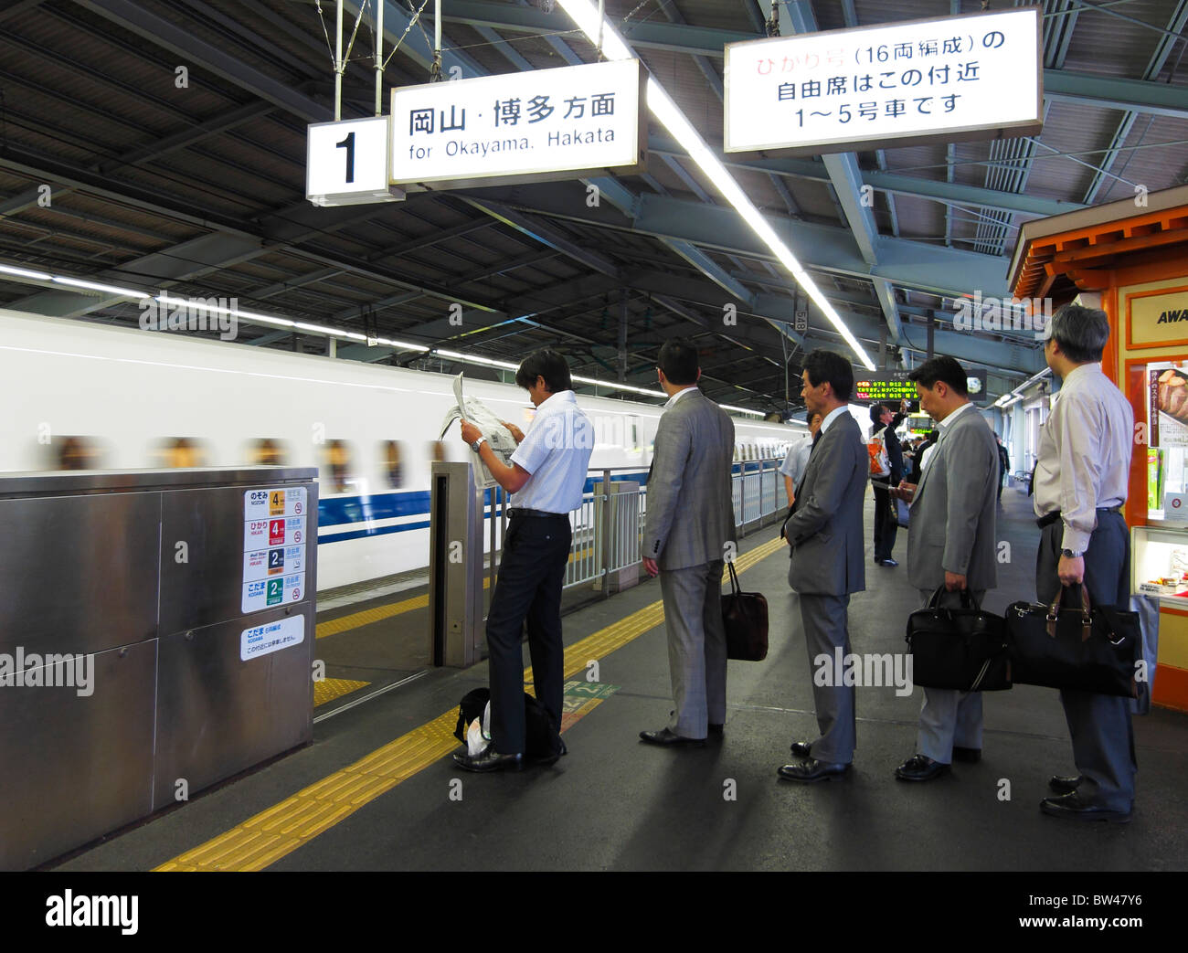Japanische Geschäftsleute Schlange, um einen Shinkansen geben Zug ...