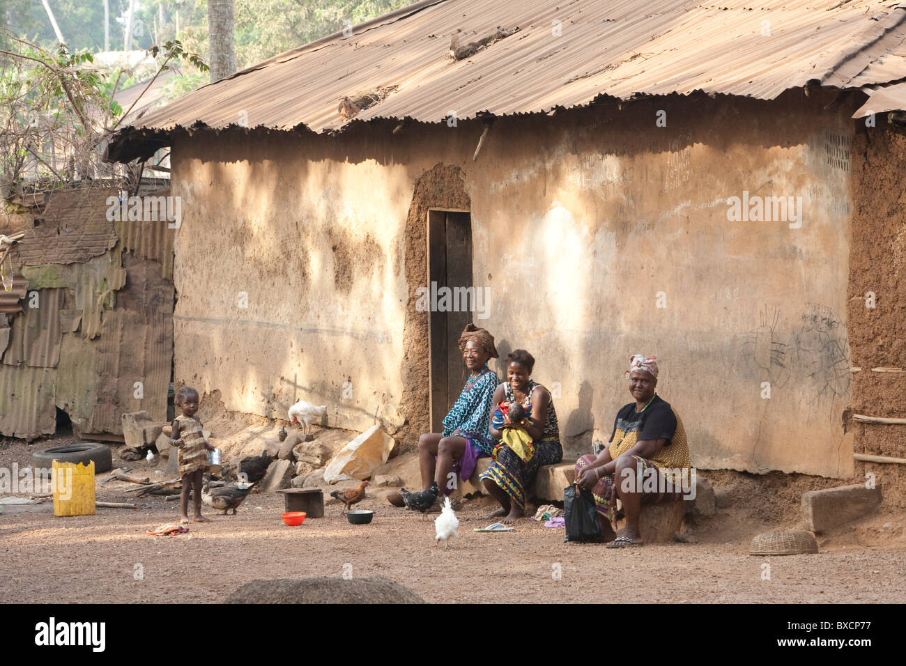 Dorfbewohner sitzen vor ihrem Haus in Port Loko, Sierra Leone ...