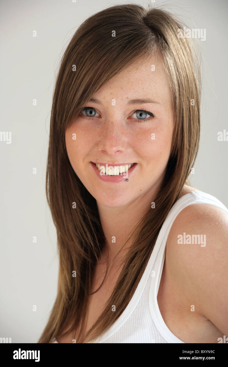 Hübsche junge Frau lächelnd in Richtung Kamera suchen Stockfotografie ...