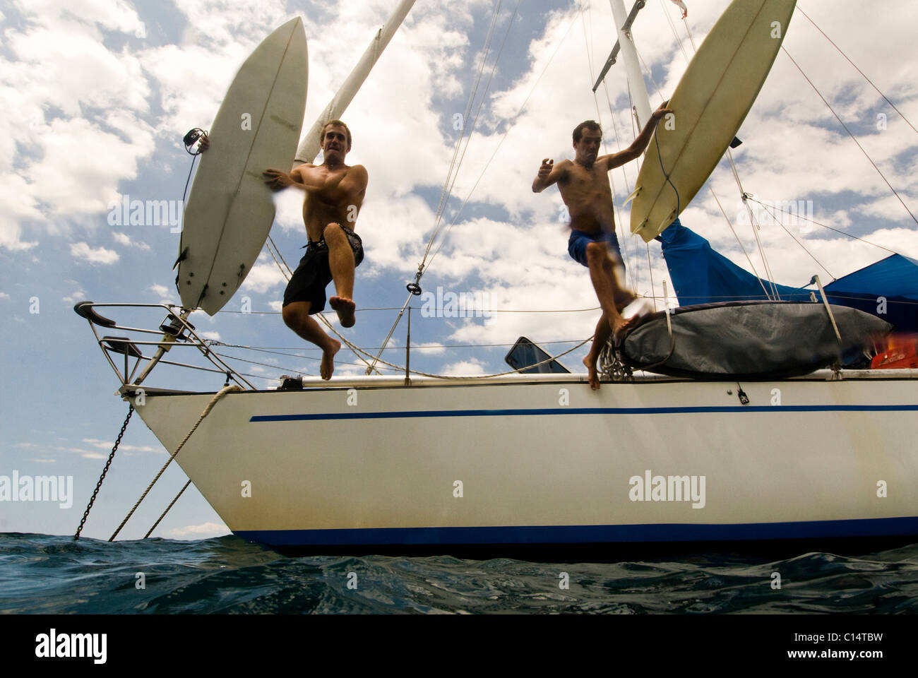 Zwei Jungs aus ihrer Position heraus für Boot springen Surfen in Costa ...