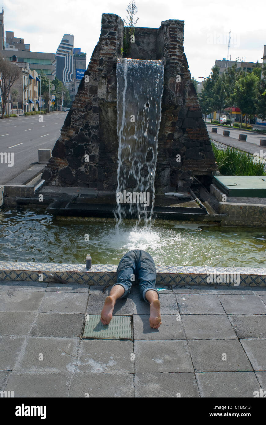 Ein Obdachloser badet in einem öffentlichen Brunnen in der Mitte von ...