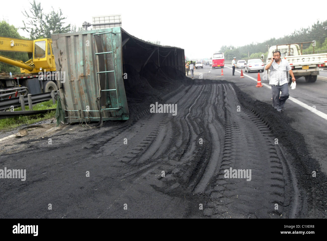 Ein LKW voll mit Sand beladen holt sich in ein Loch auf der Straße in ...