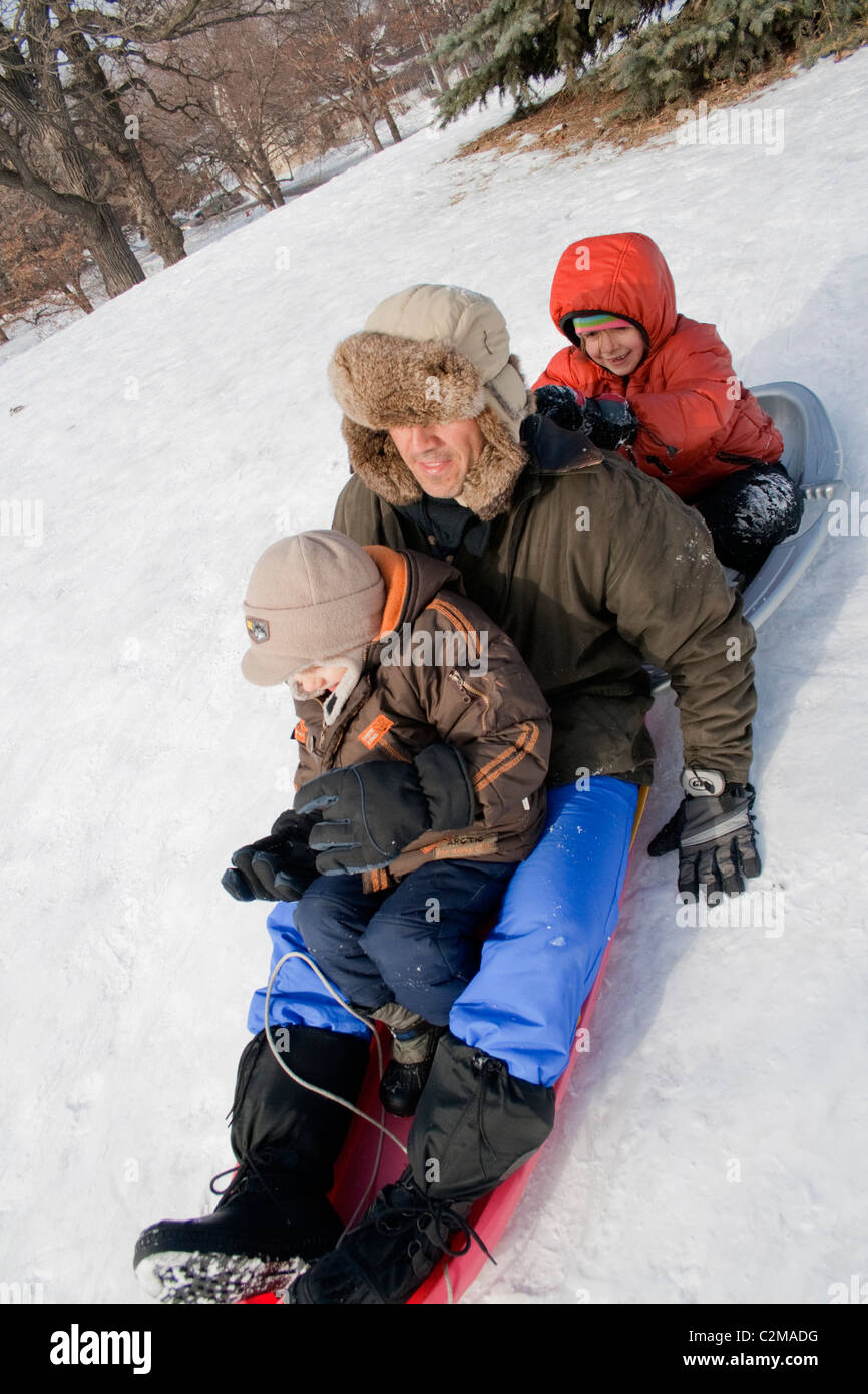 Jungen und Mädchen im Alter von 6 und 7 Abrutschen schneereichen Winter ...
