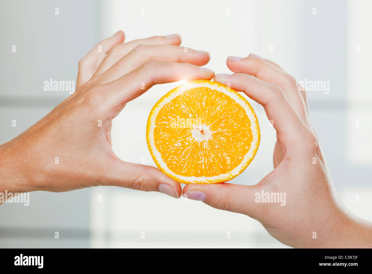 Deutschland, Köln, menschliche Hand halten eine halbe orange ...