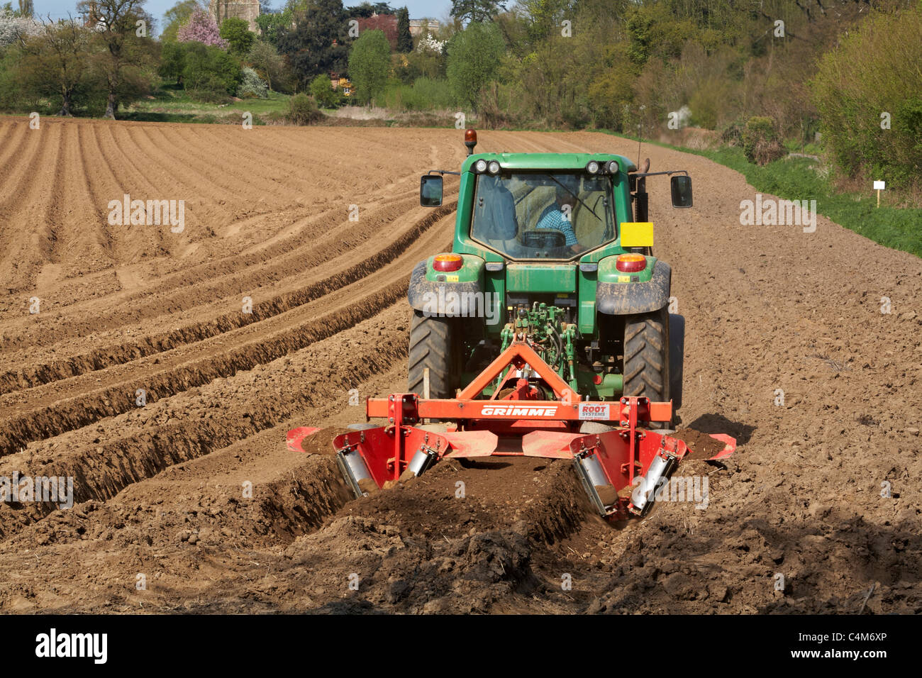 Arbeitende landwirtschaftliche Zugmaschine mit Maschinen zum Herstellen ...