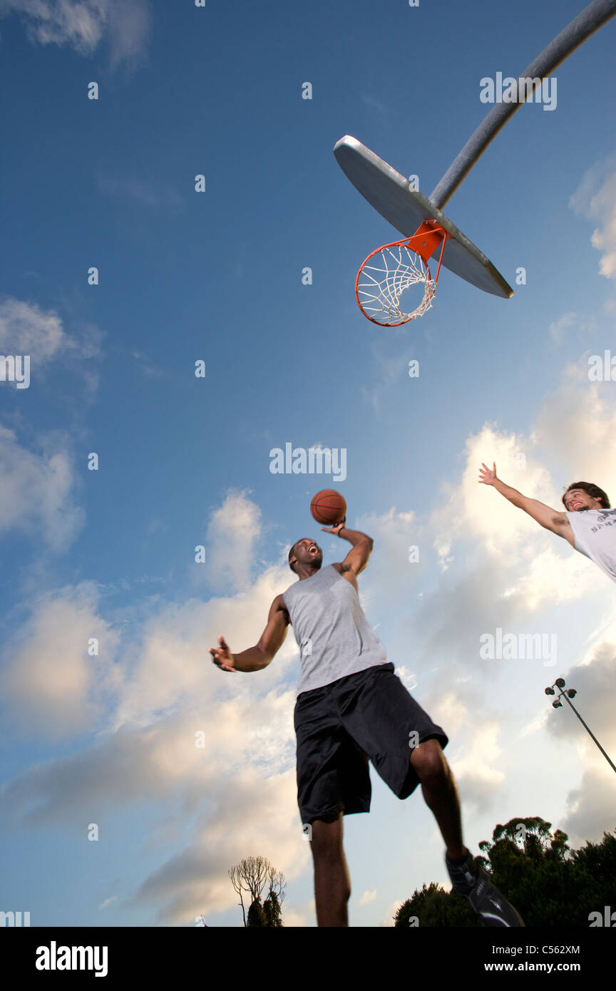 Männchen bei Outdoor-Basketball-Spiel, erzielte auf der Suche nach oben ...